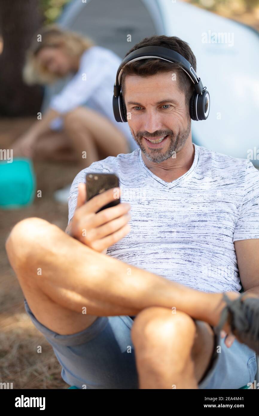 man using mp3 player at campsite Stock Photo - Alamy
