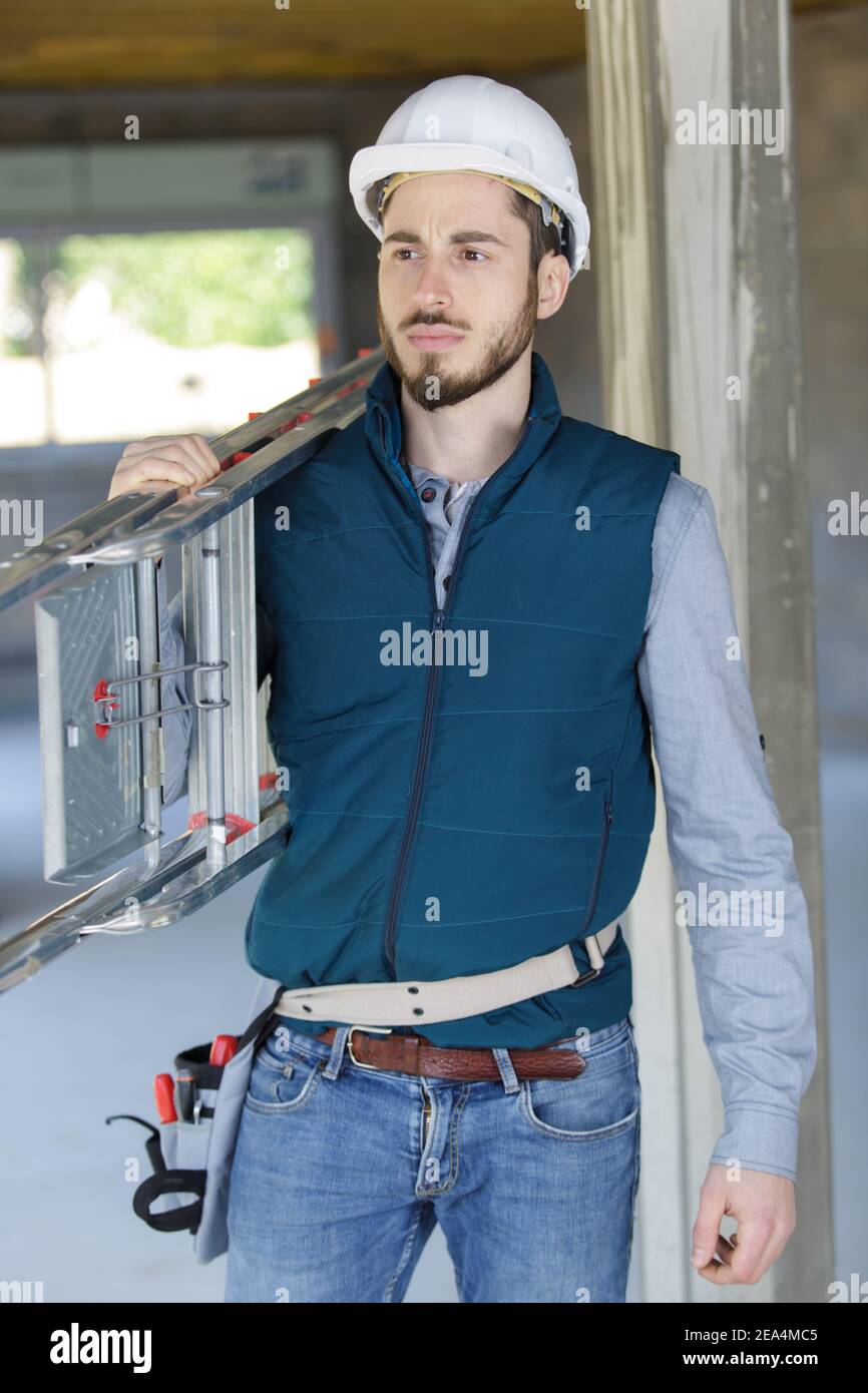carpenter carrying ladder at construction site Stock Photo - Alamy