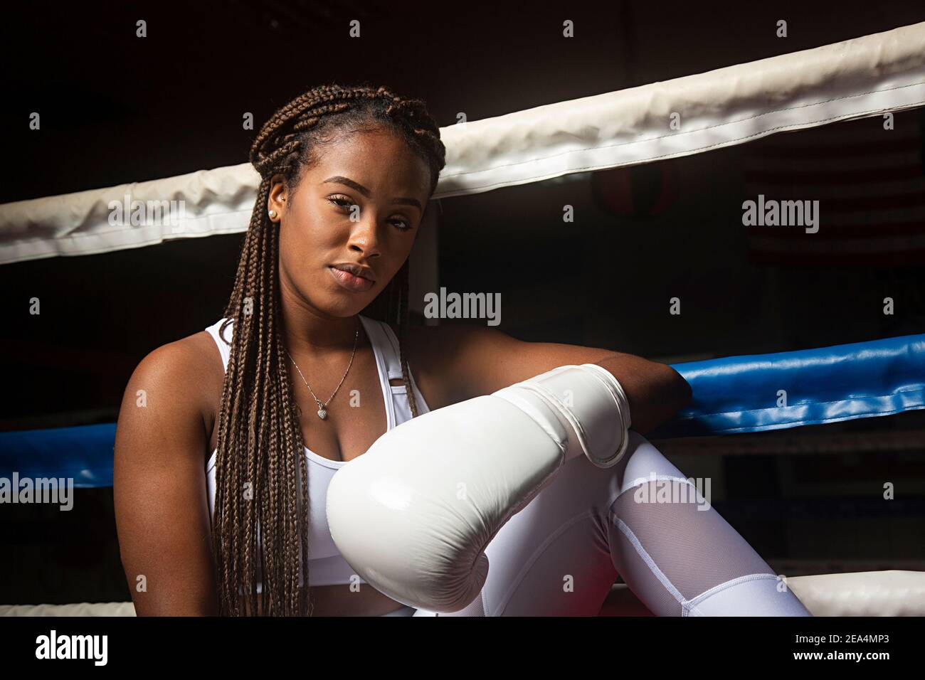 Portrait of beautiful young afro boxer girl looking at camera on boxing ...
