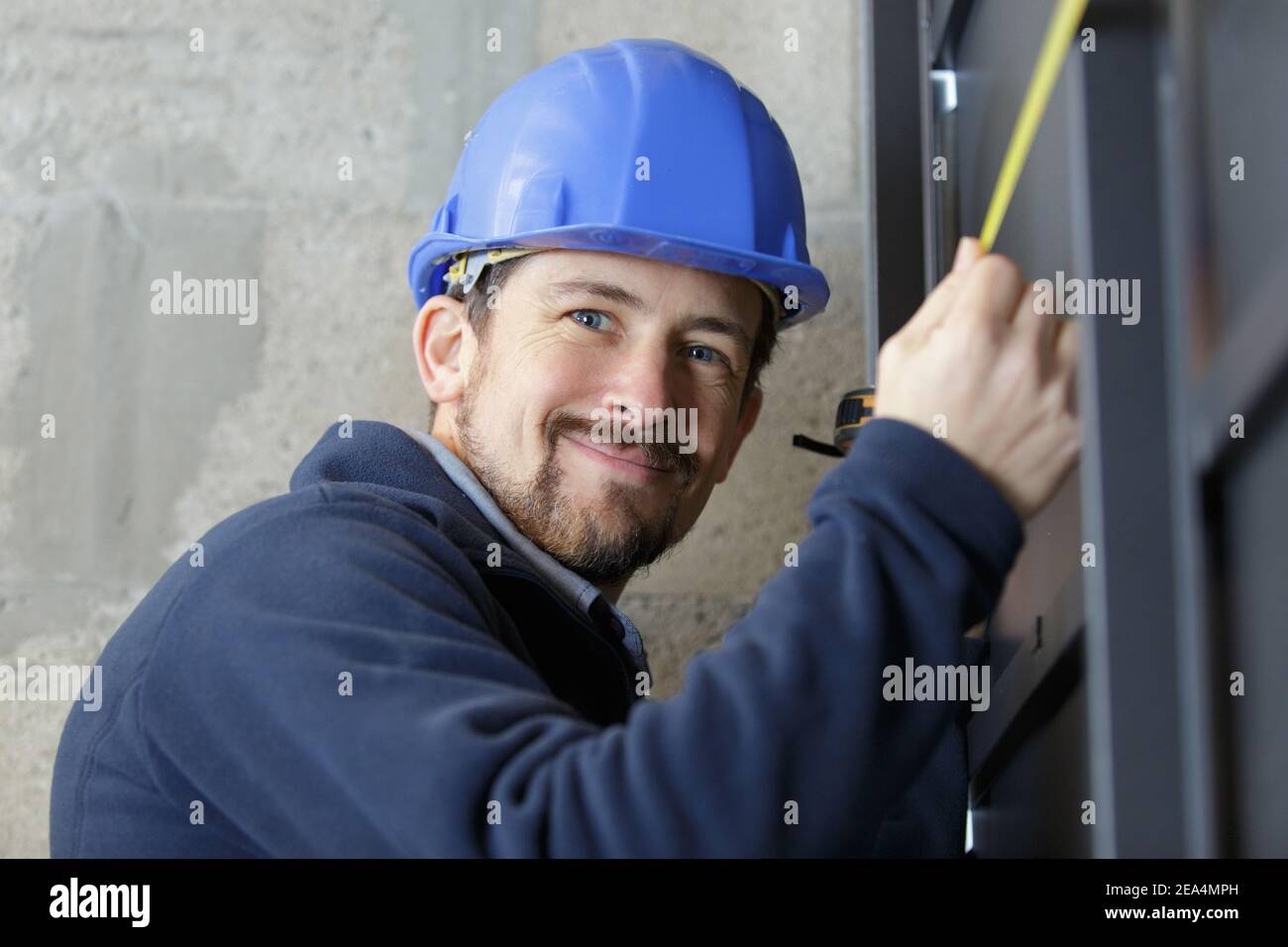 portrait of workman using tape measure Stock Photo - Alamy