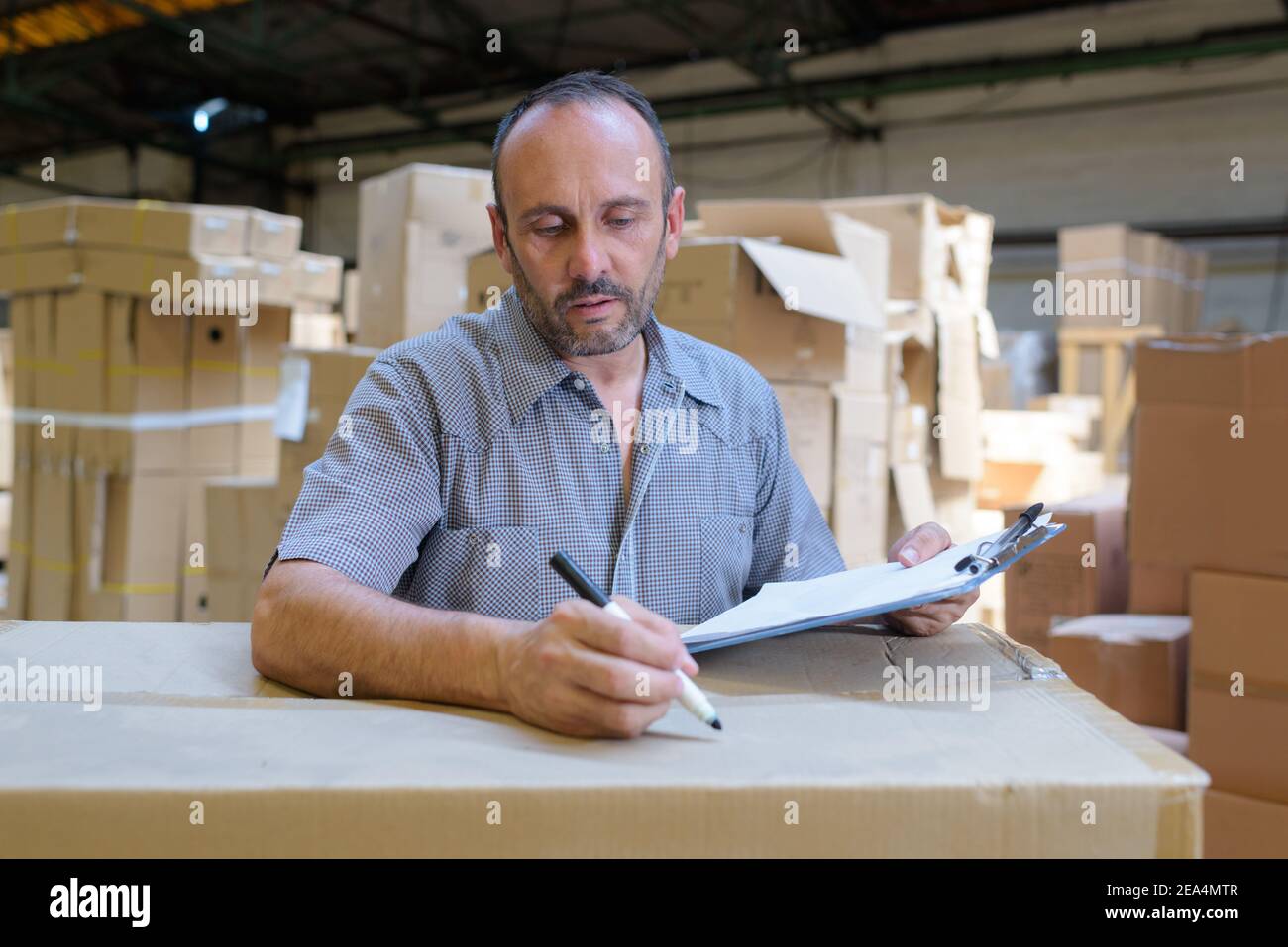 man in warehouse writing notes Stock Photo - Alamy