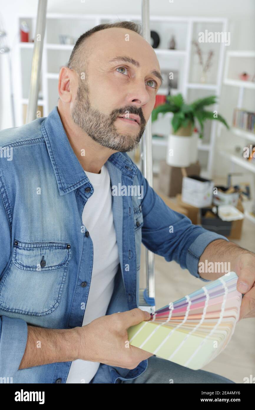 a middle aged man choosing a paint color Stock Photo - Alamy