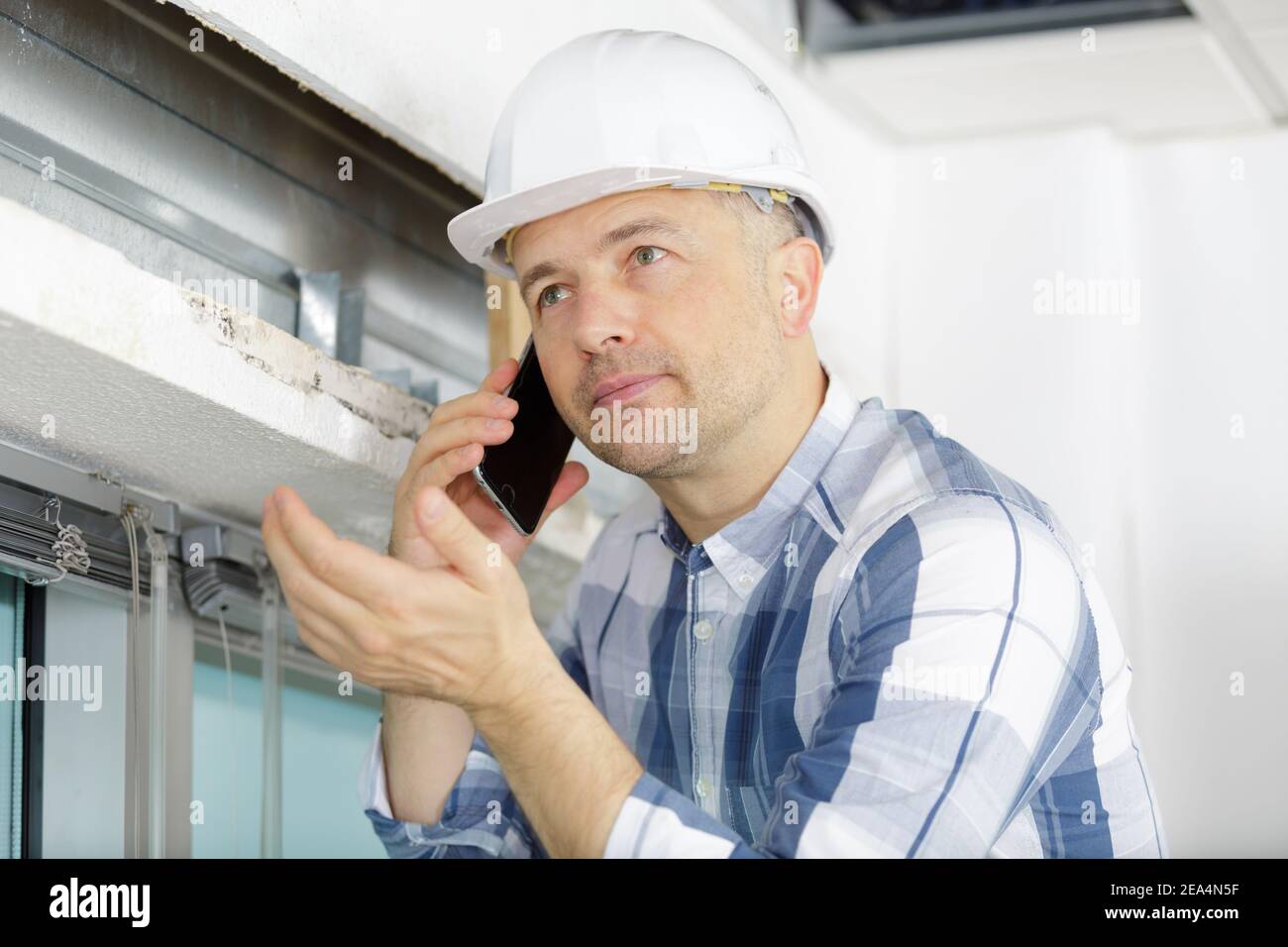 construction worker having serious phone conversation Stock Photo - Alamy