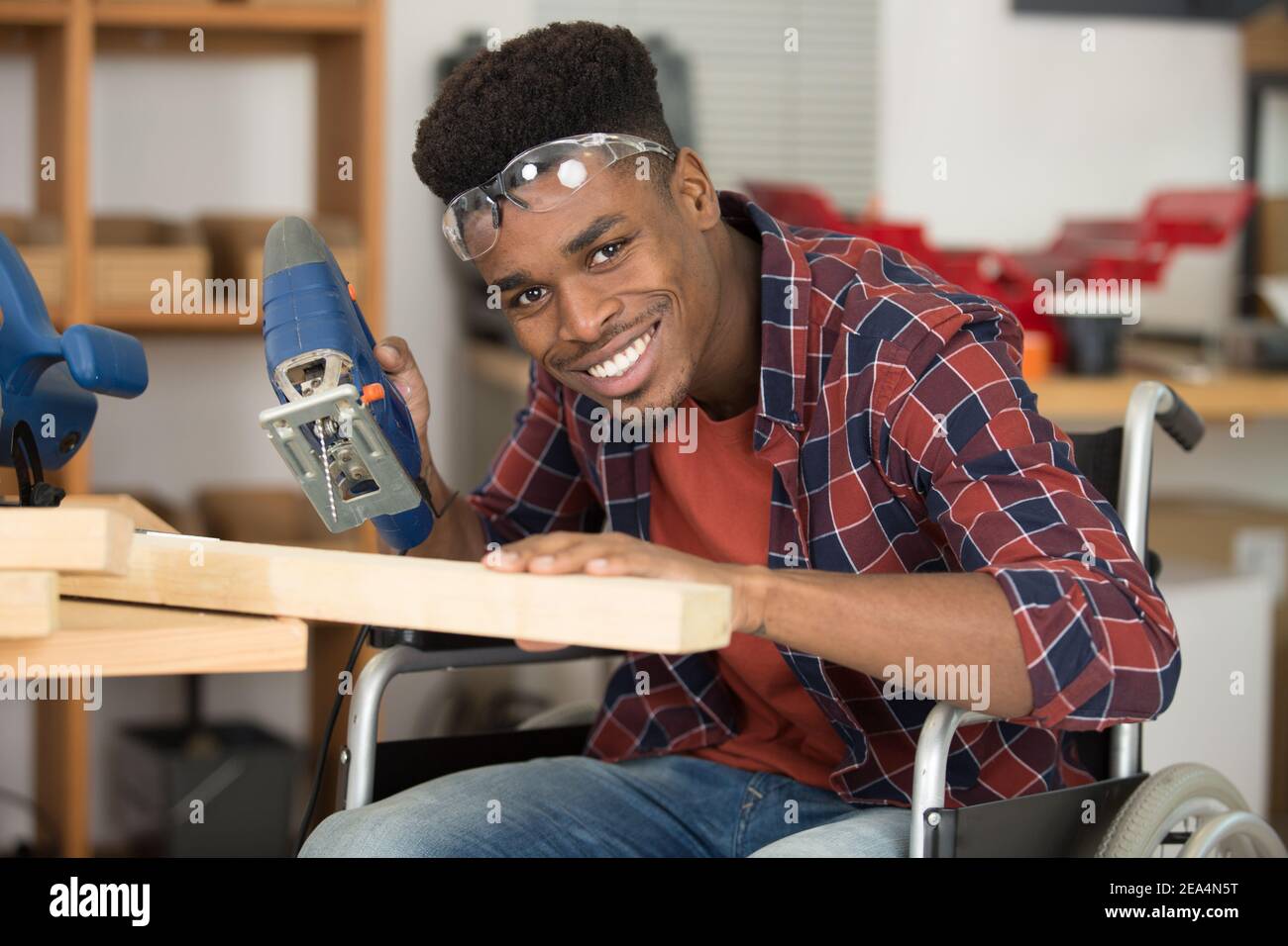 close up of carpenter in wheelchair using electric jigsaw Stock Photo ...