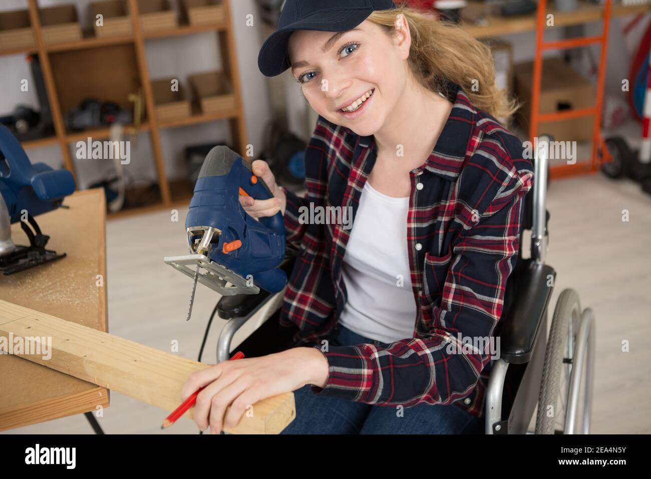 disabled female carpenter using jigsaw to cut wood Stock Photo - Alamy