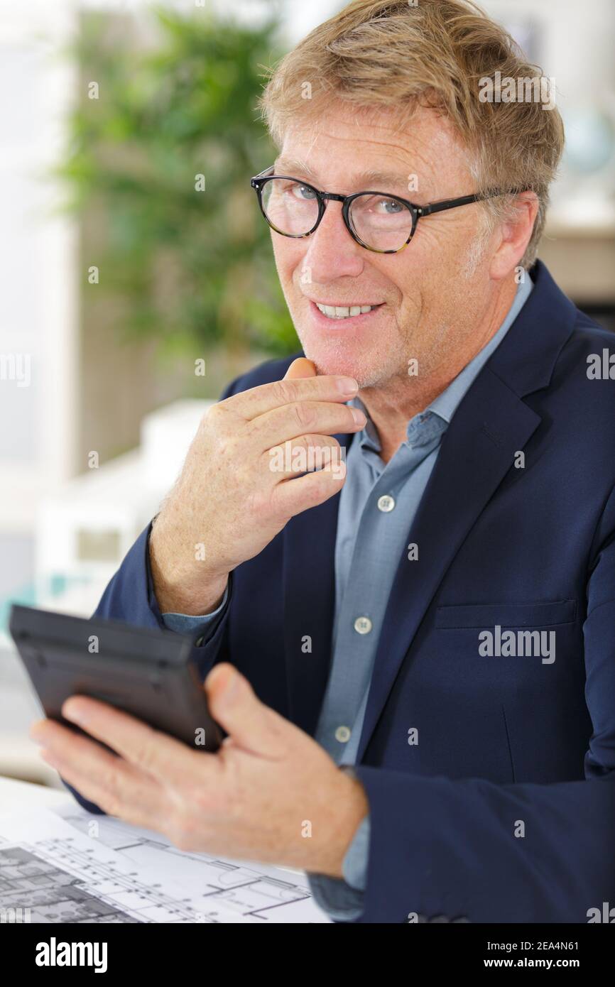 architect man working on blueprint plans with a calculator Stock Photo ...