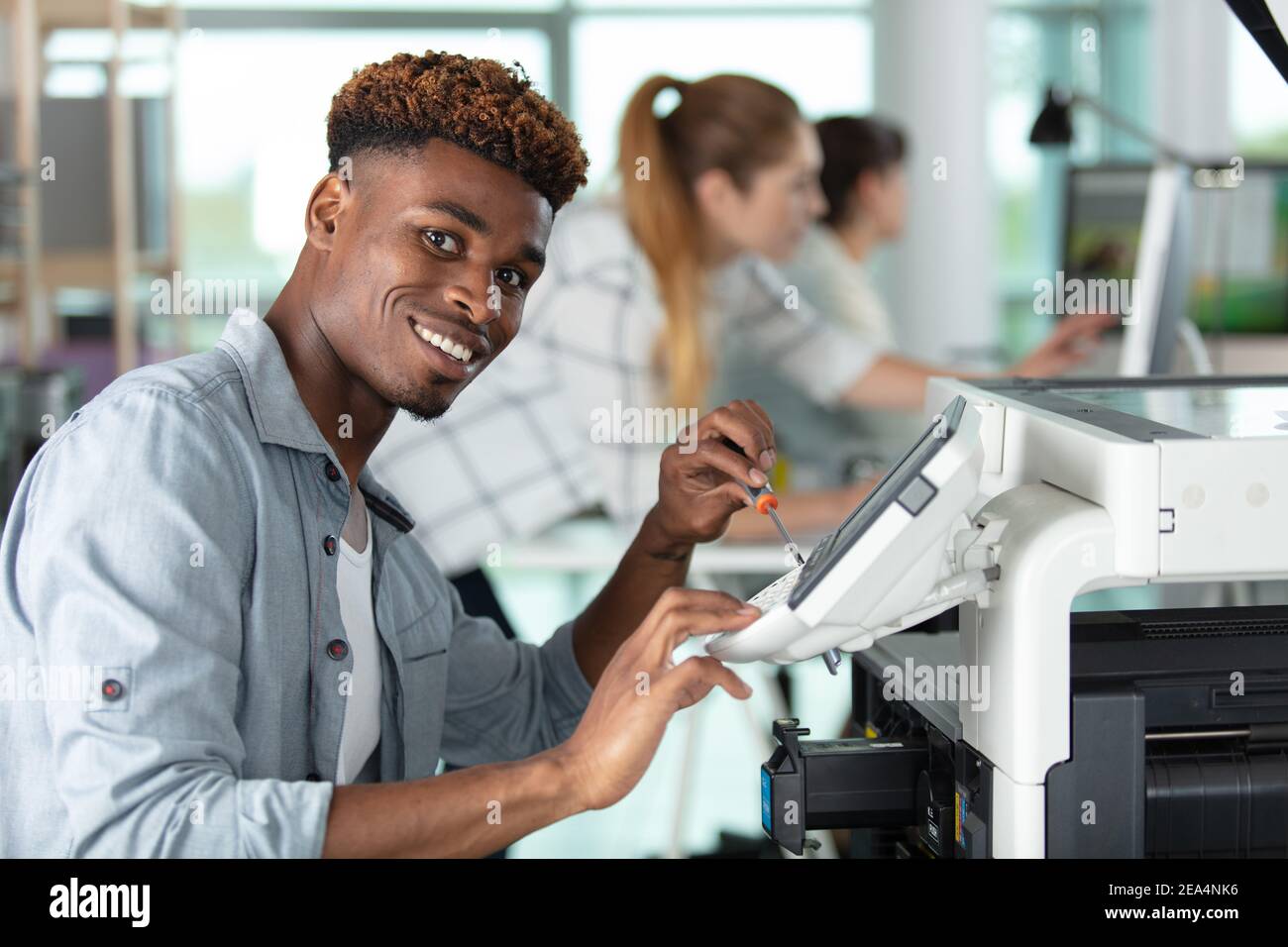 happy young man fixing a printer Stock Photo - Alamy