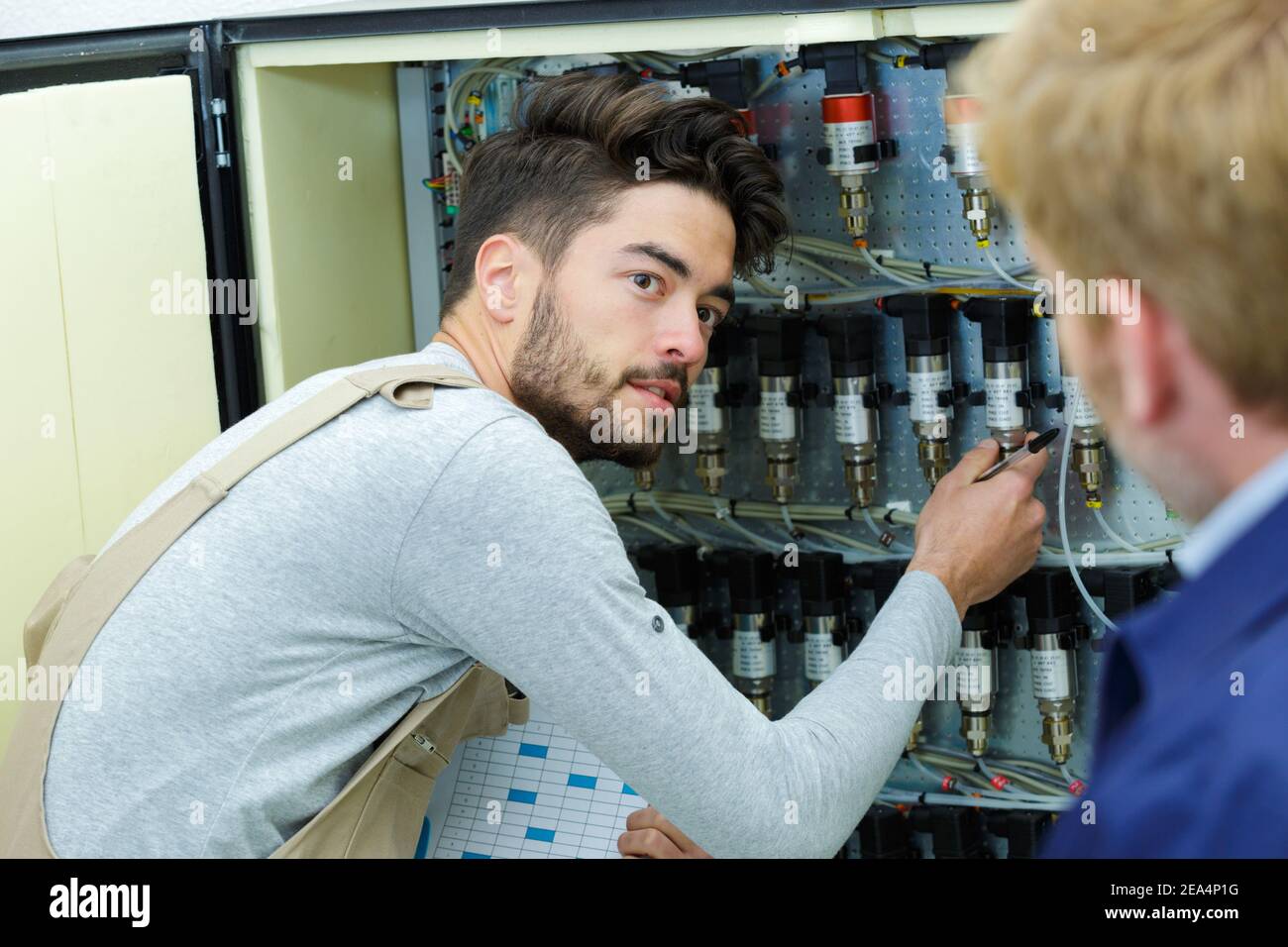 two people checking cables with clipboard Stock Photo - Alamy