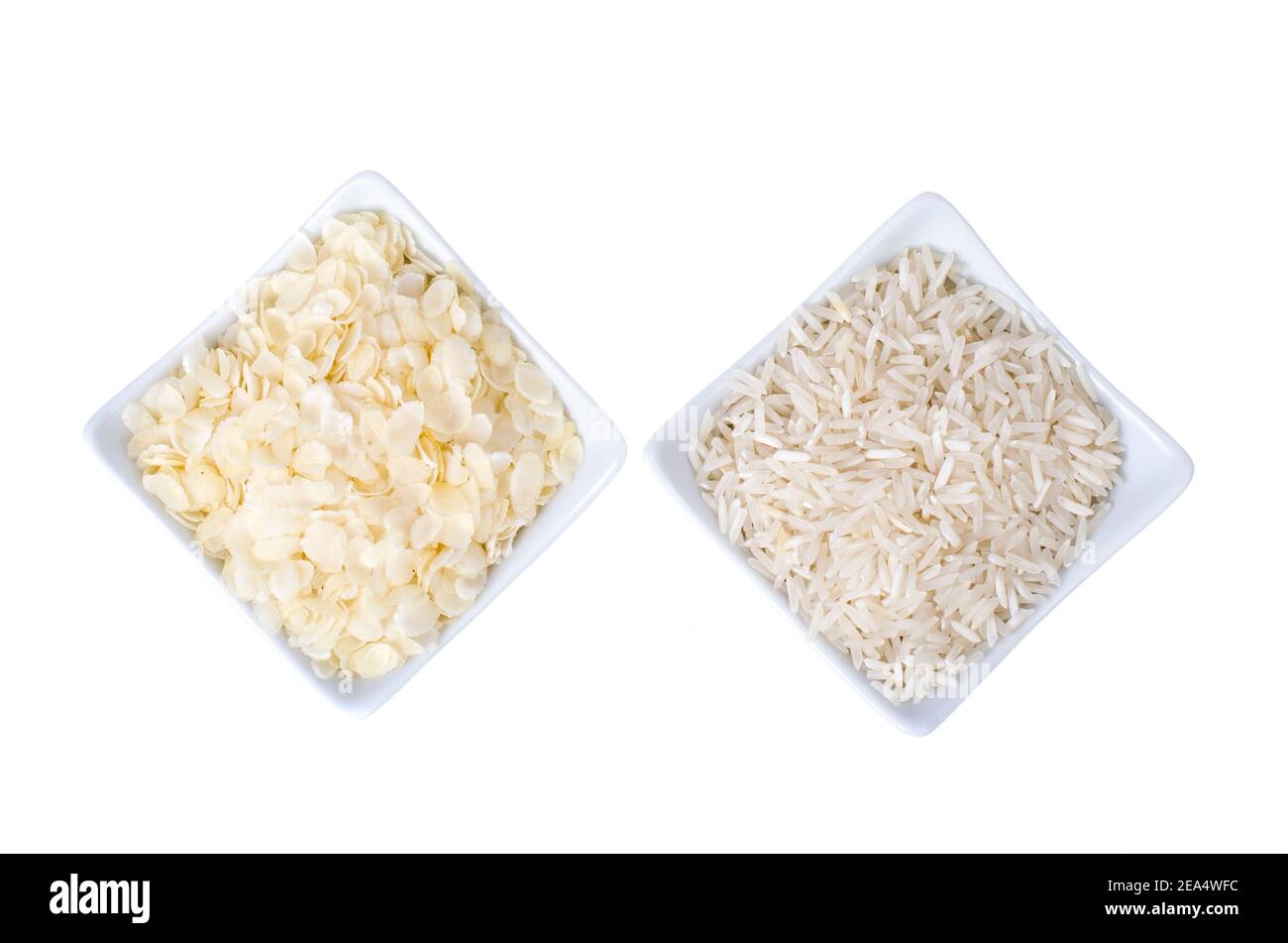 Whole grains of rice and flattened rice flakes in bowls, isolated on ...