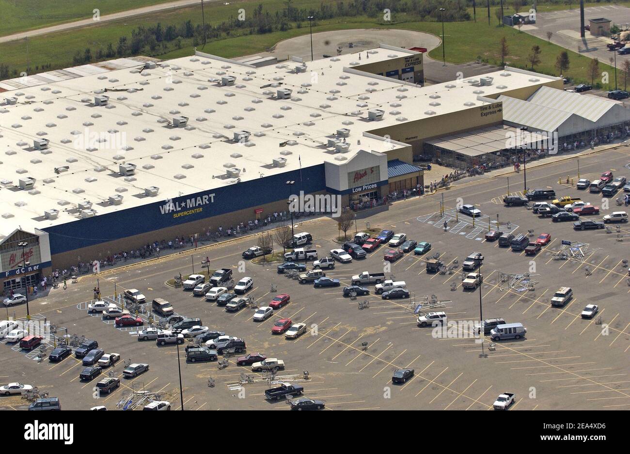 Residents of Biloxi wait in line outside a local Wal-mart, which ...