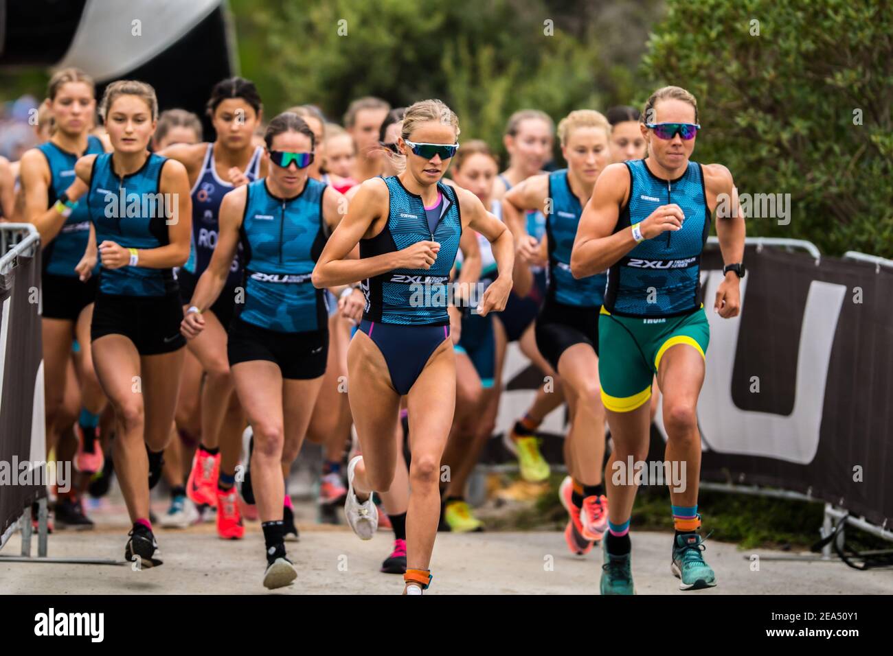 A large group of female triathletes in a running race at the start of ...