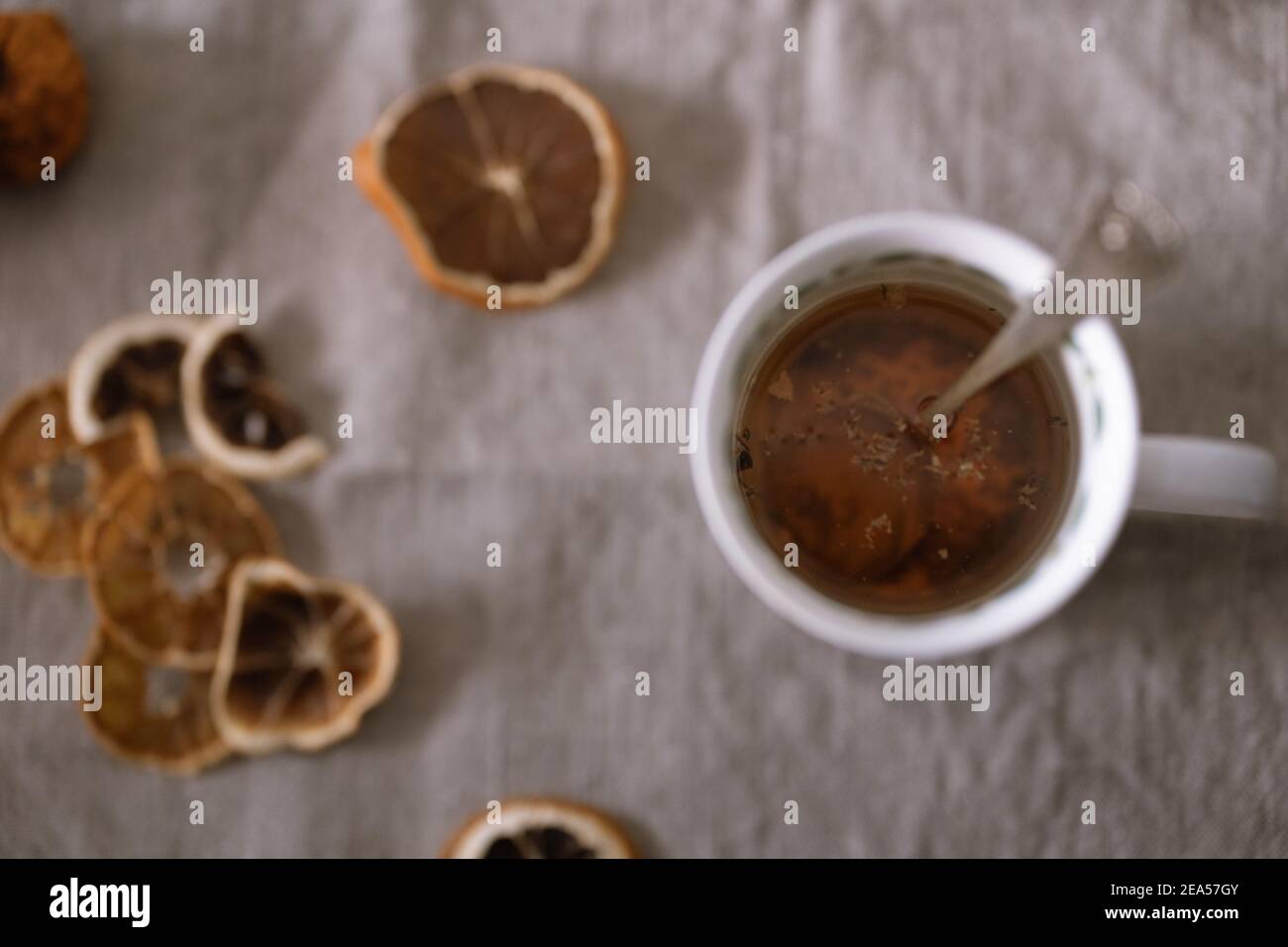 A top view of a dried lemon tea in a white mug on a fabric surface ...