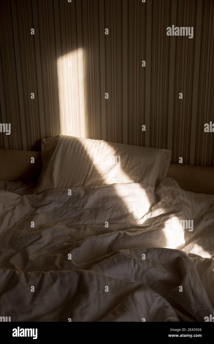 Sunbeam falls on the bed. The sun rays through window in the morning ...