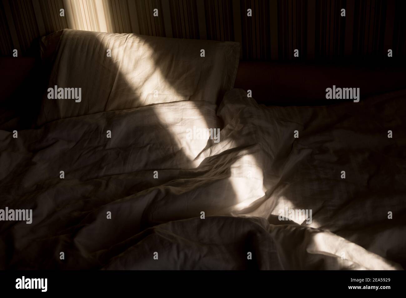 Sunbeam falls on the bed. The sun rays through window in the morning ...