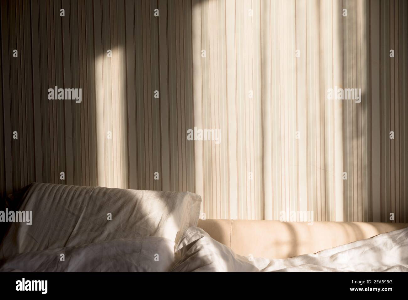 Sunbeam falls on the bed. The sun rays through window in the morning ...