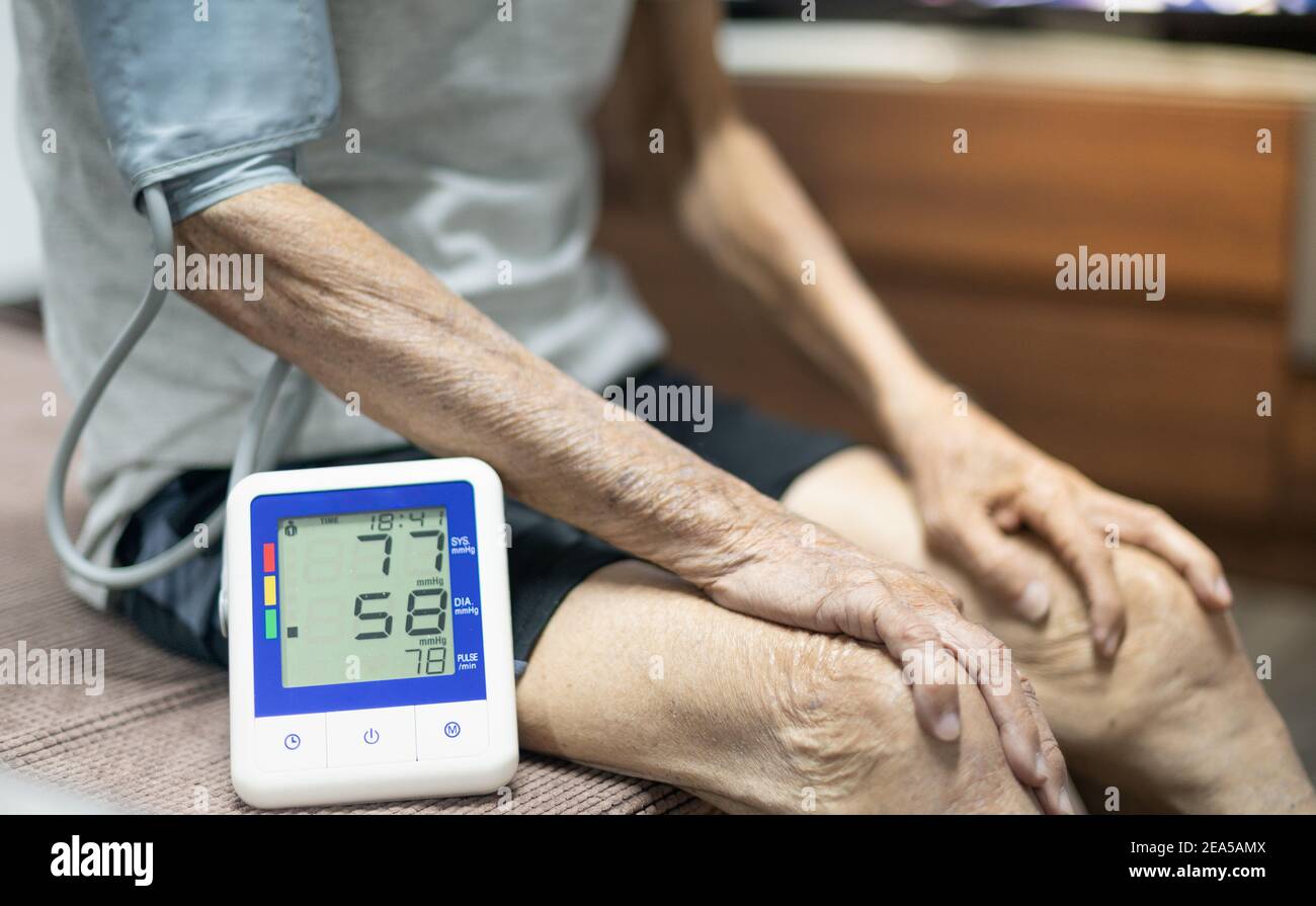 The old man check blood pressure monitor and heart rate monitor with ...