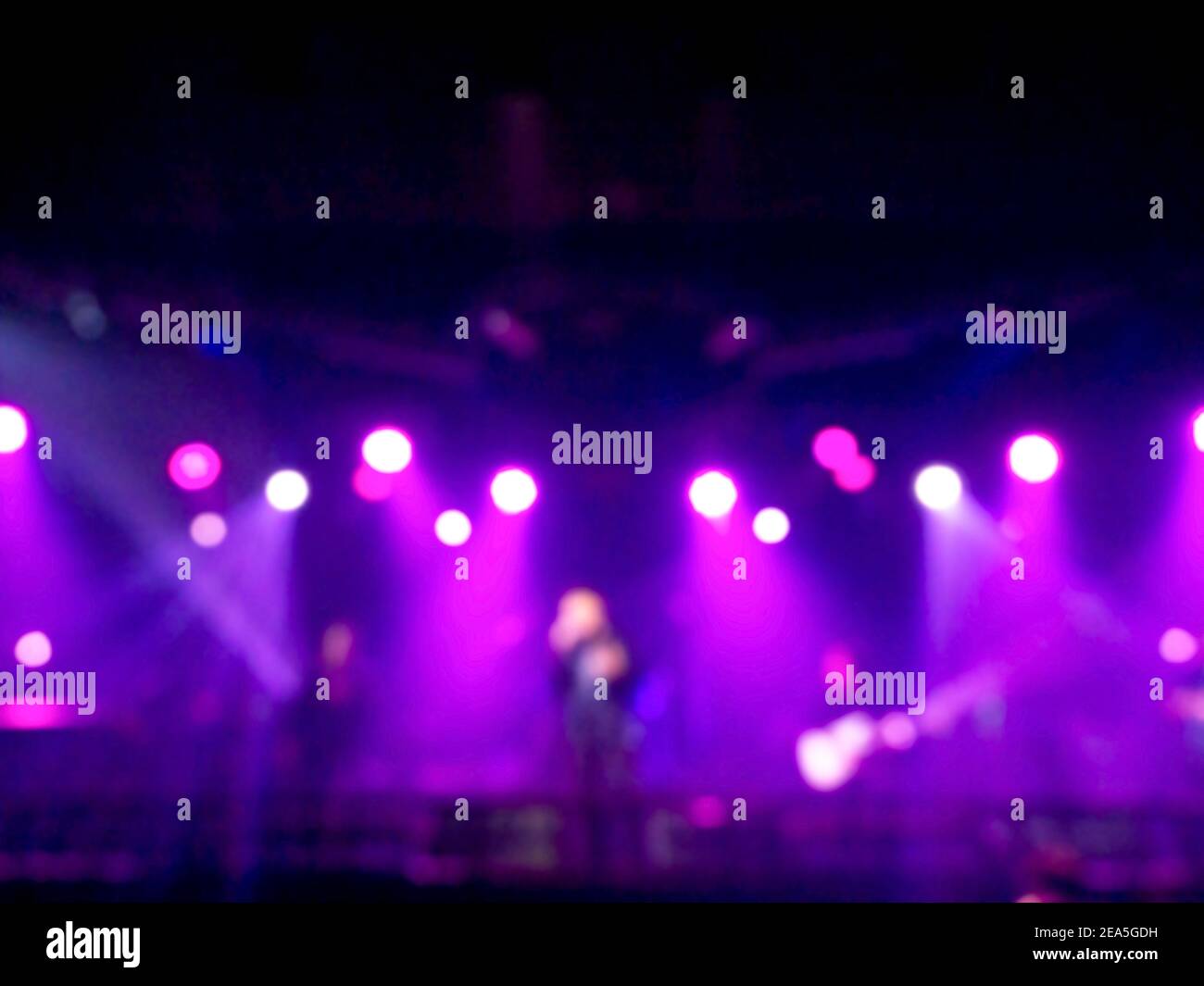 Blurred rock concert performing on stage with musician with purple ...