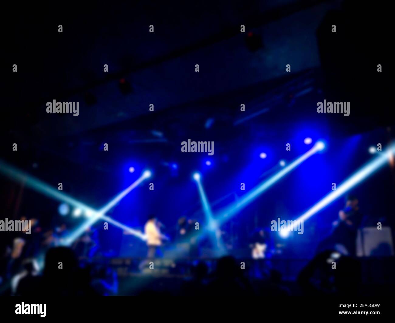 Blurred rock concert performing on stage with musician with blue light ...