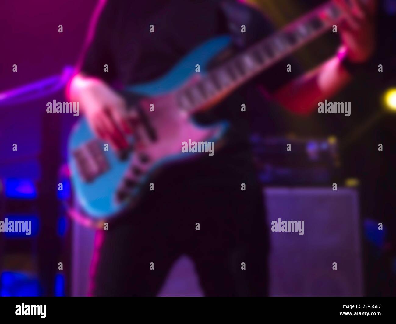 Blurred Asian musician man, bass guitarist playing solo bass guitar on ...