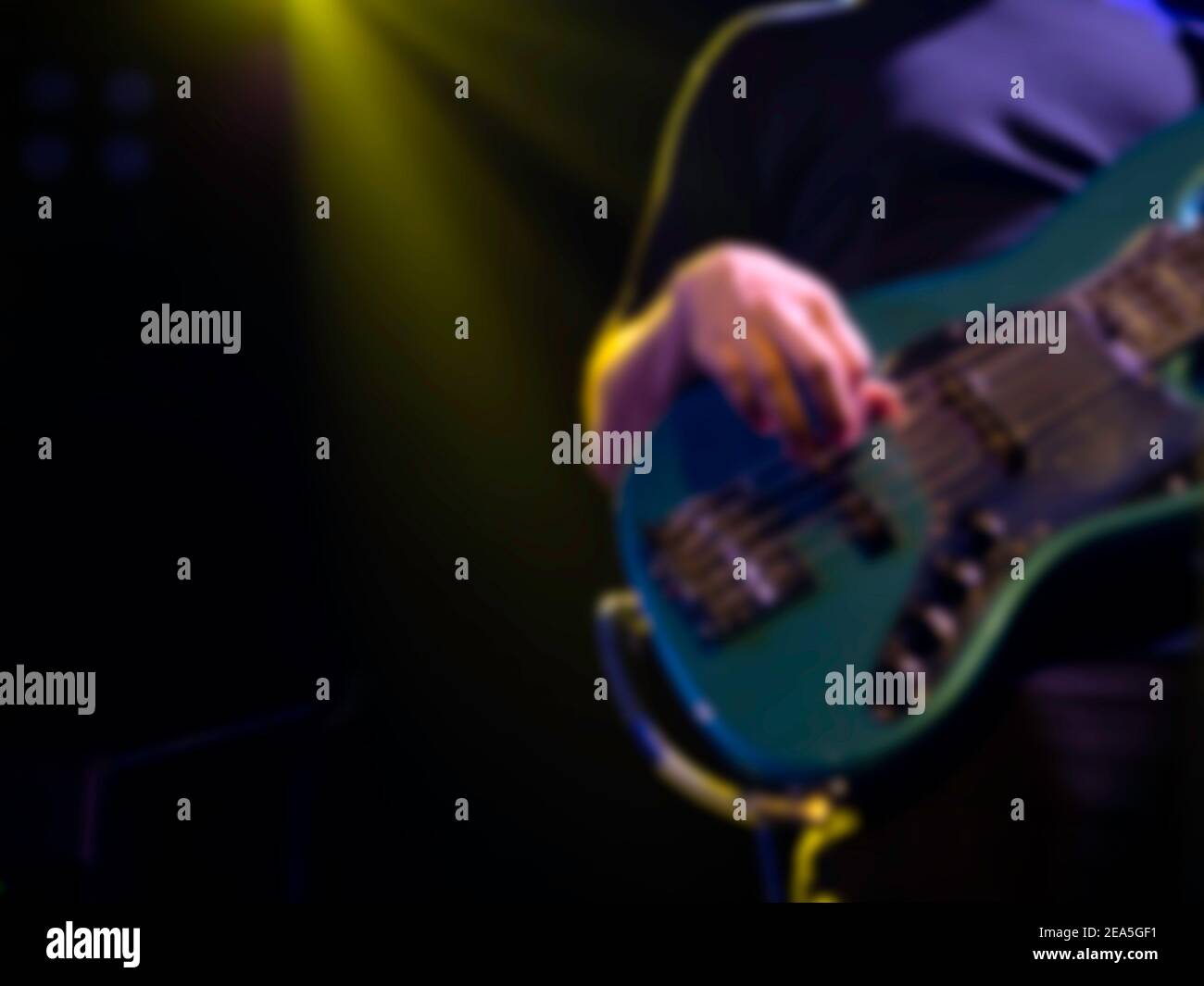 Blurred Asian musician man, bass guitarist playing solo bass guitar on ...