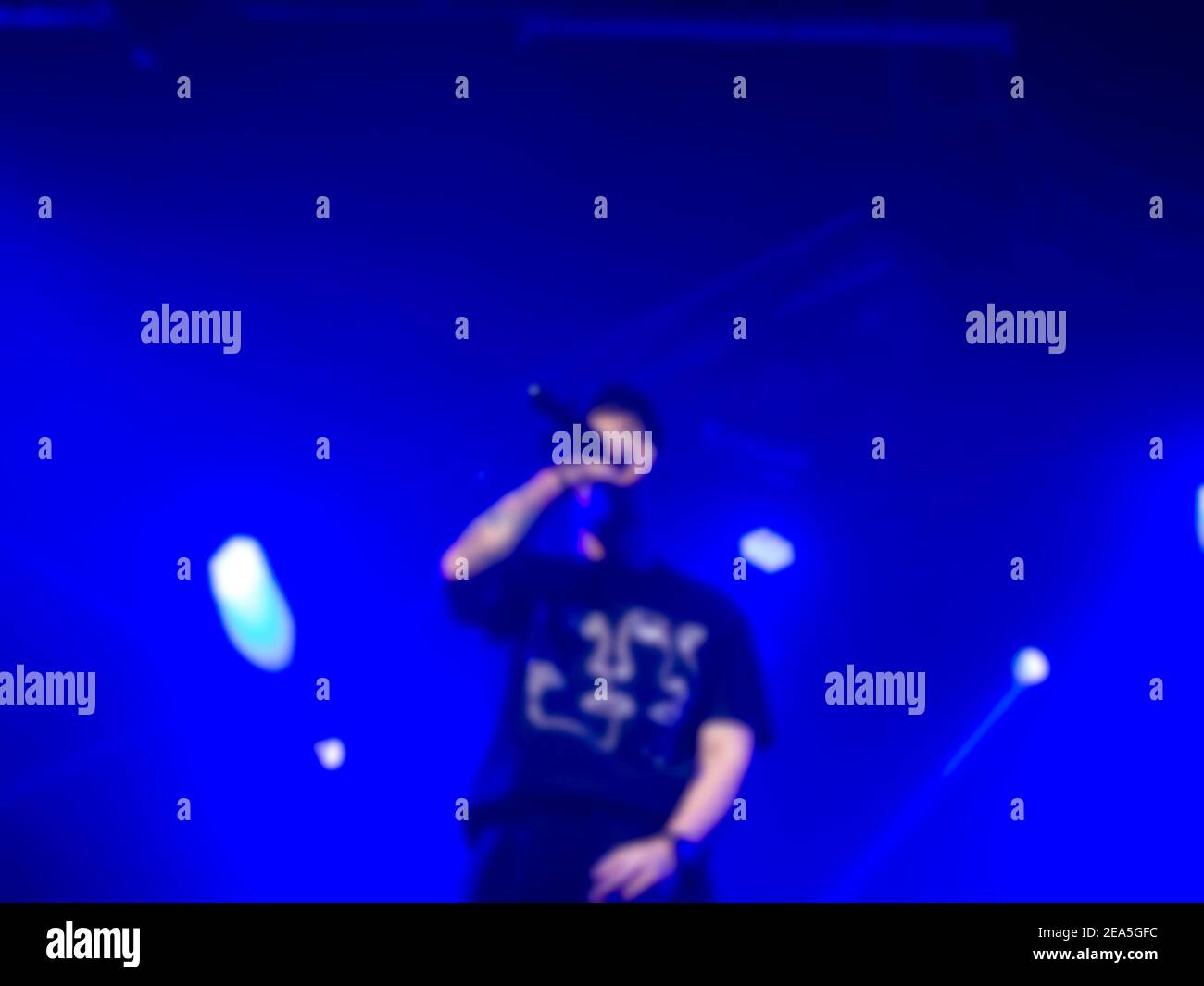 Blurred vocalist man, singer holding microphone and singing a song on ...