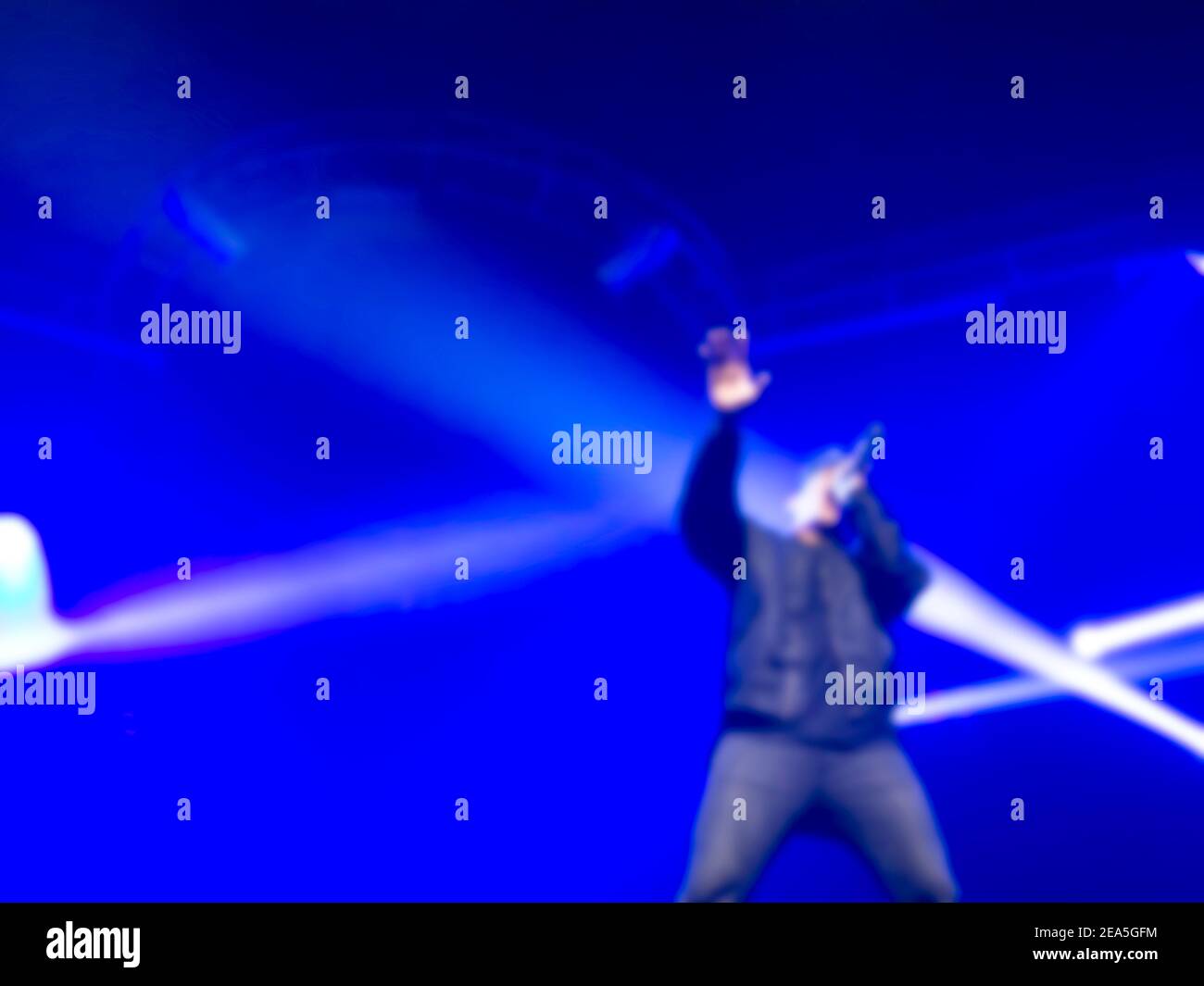 Blurred vocalist man, singer holding microphone and singing a song on ...