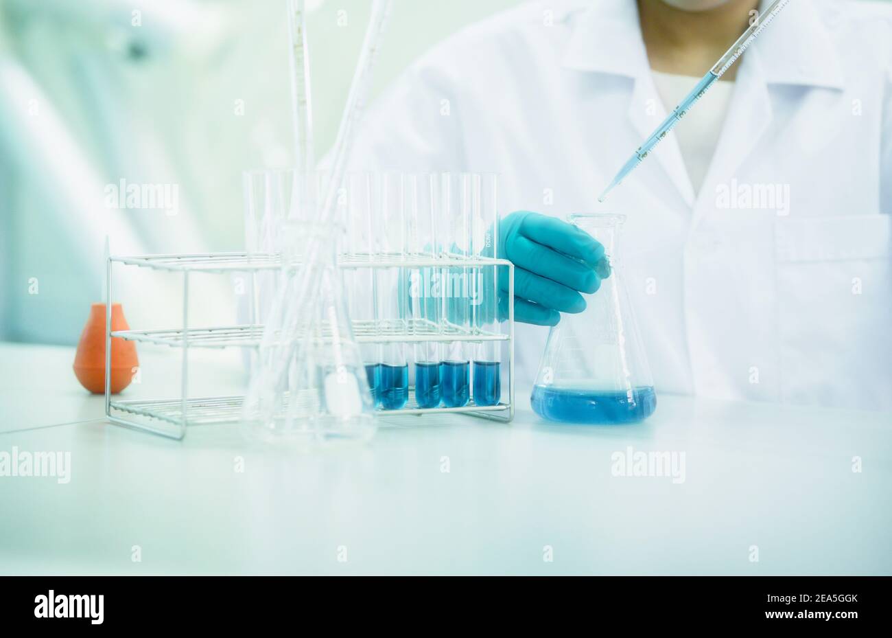 Doctor or scientist using pipette to drop a sample to test plate in ...