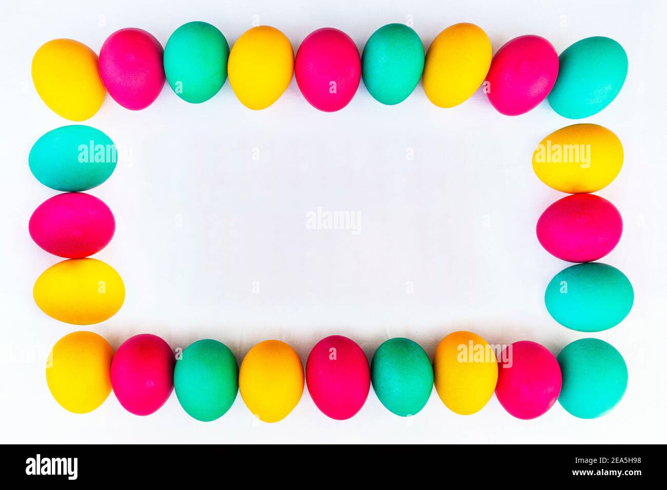 lots of colorful Easter eggs laid out in a rectangular frame. Empty ...