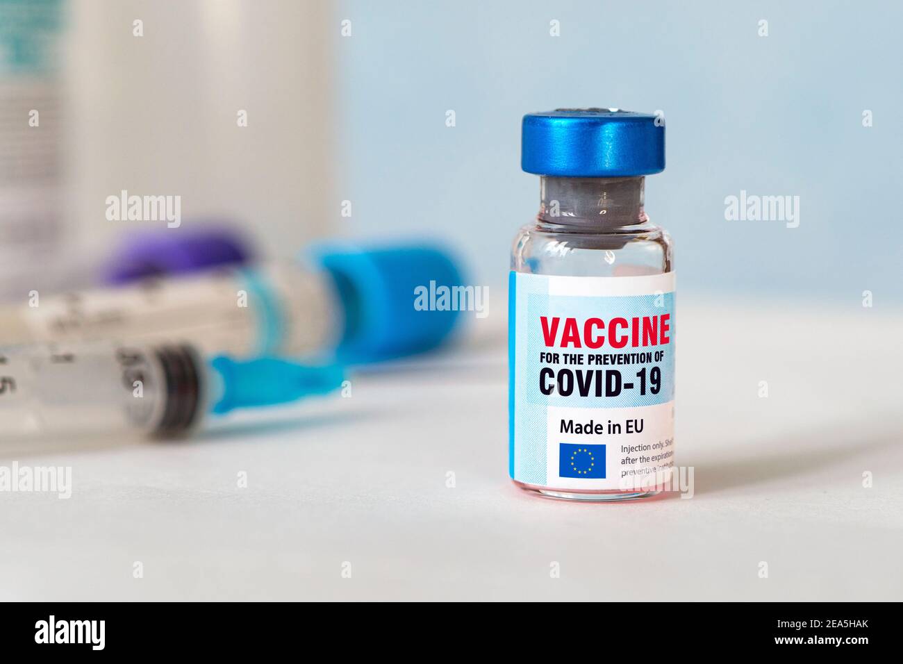 Medical glass vial and plastic syringe for injection on white table ...