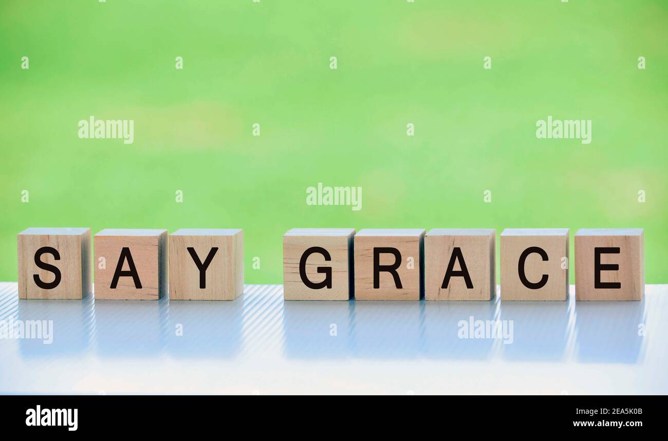 Say grace text on wooden cube block with blurred green grass background ...