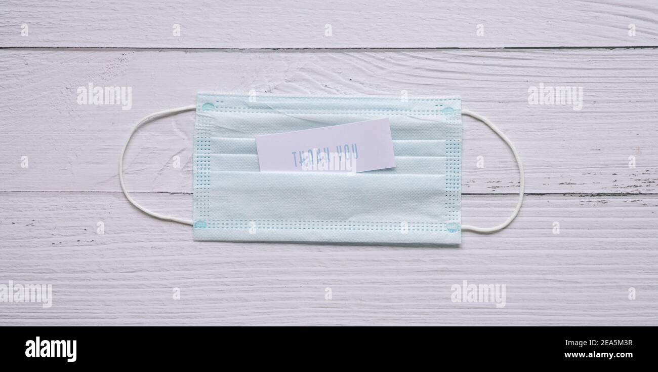 Thank you note on top of medical face mask. Top view. Appreciation to ...