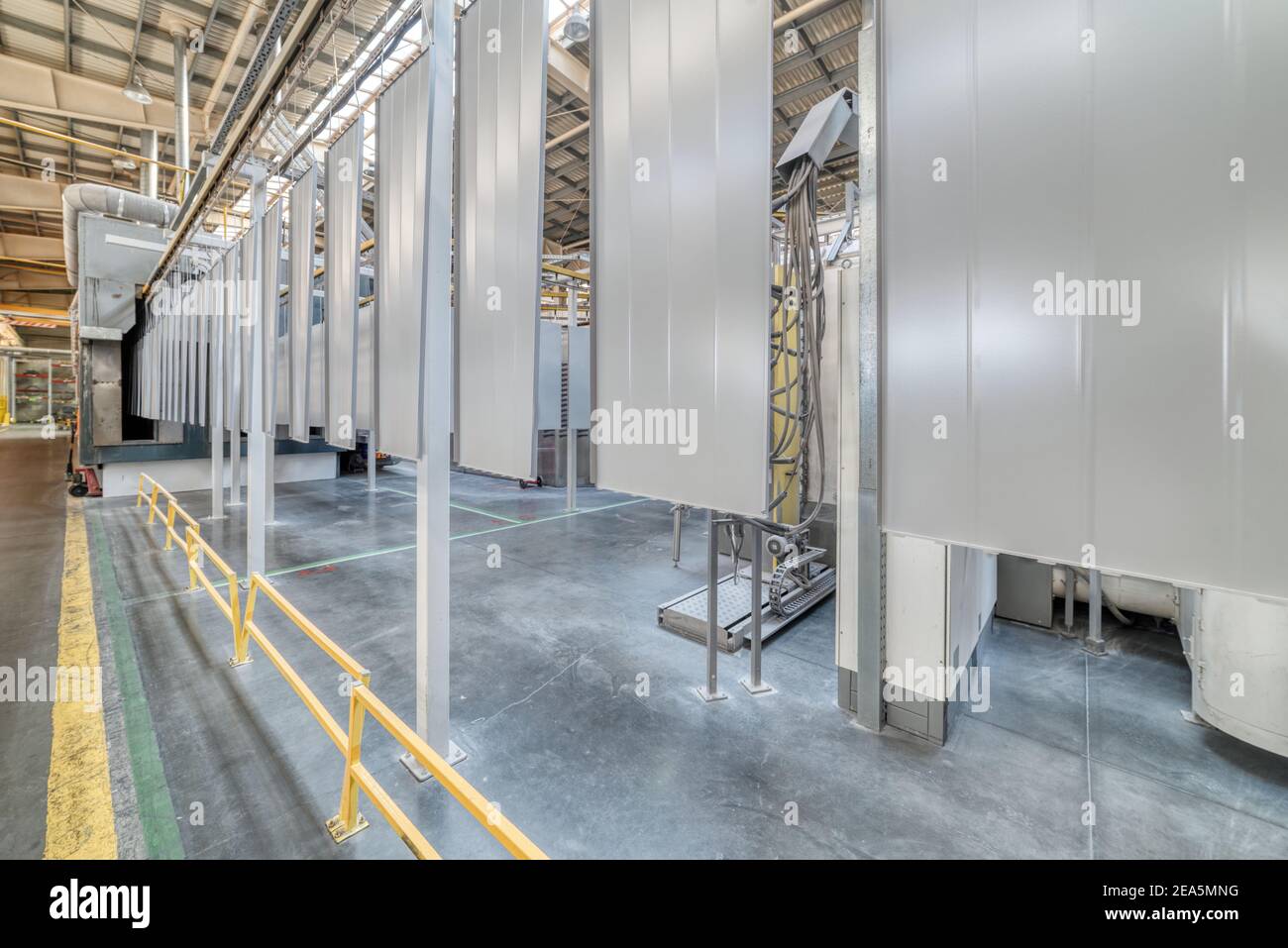 Powder coating line. Metal panels are suspended on an overhead conveyor ...
