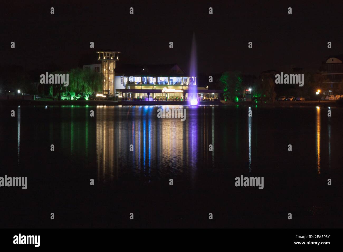 Colorful lights from building reflects on the lake water surface at ...