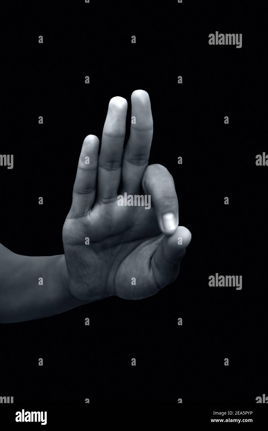 Shot of a male hand showing Gyan mudra isolated on black background ...