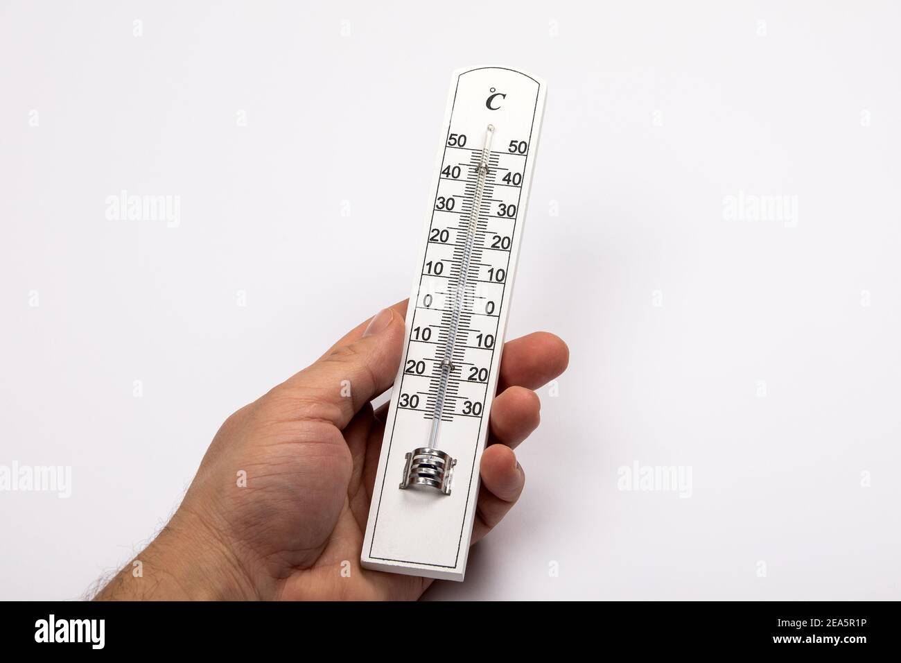 Wooden thermometer with Celsius scale in a man's hand on a white ...