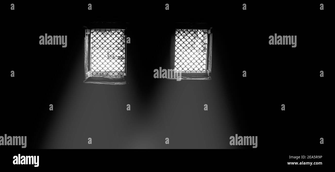 Cinematic dark mood shot of windows with some sunlight coming through ...