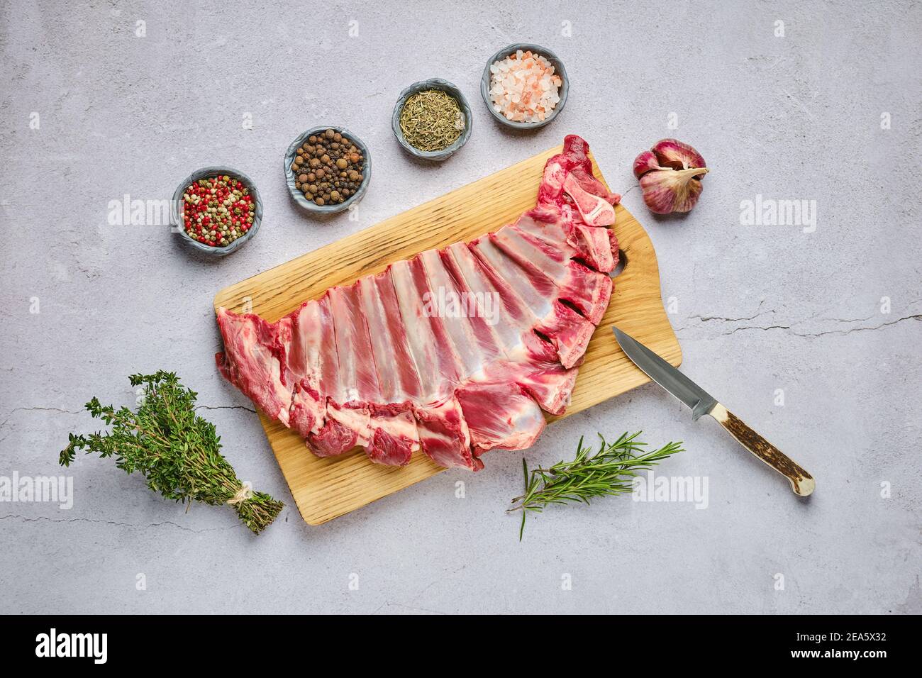 Overhead view of raw fresh deer ribs with spice and herb over concrete ...