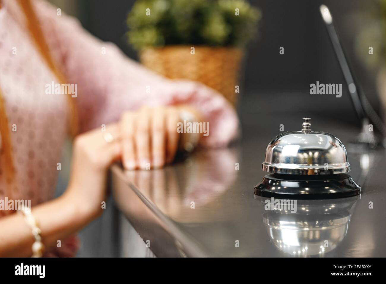 Blonde woman standing at front desk hotel reception Stock Photo - Alamy