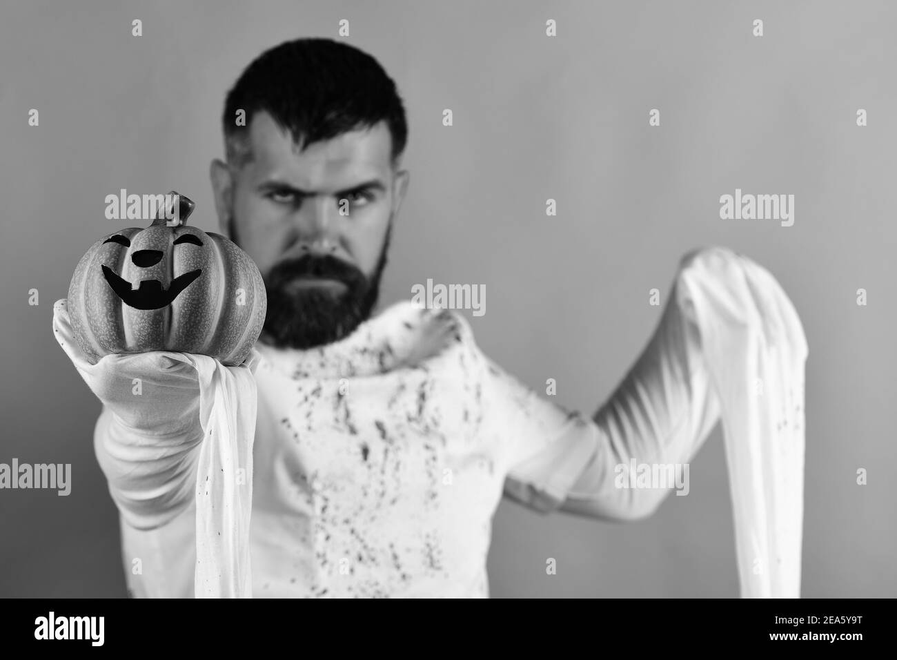 Halloween character in white long sleeved ghost costume. Guy with beard ...