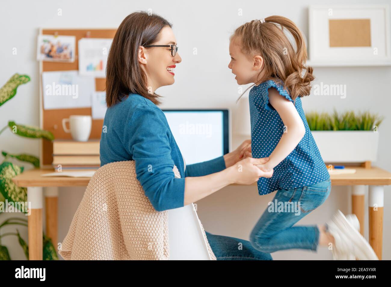 Young mother with child working on the computer. Family at home. Remote ...