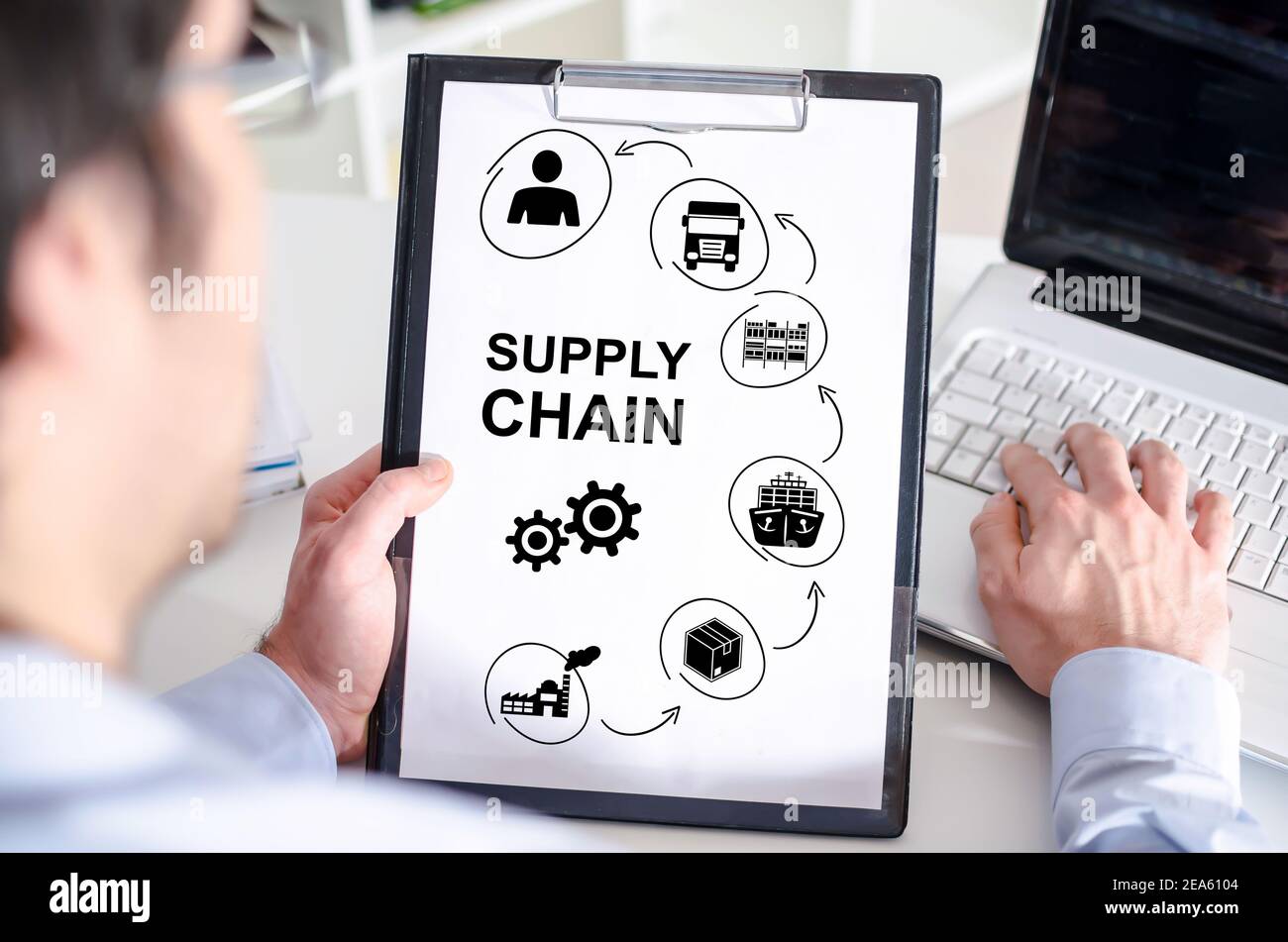 Man holding a clipboard with supply chain concept Stock Photo - Alamy