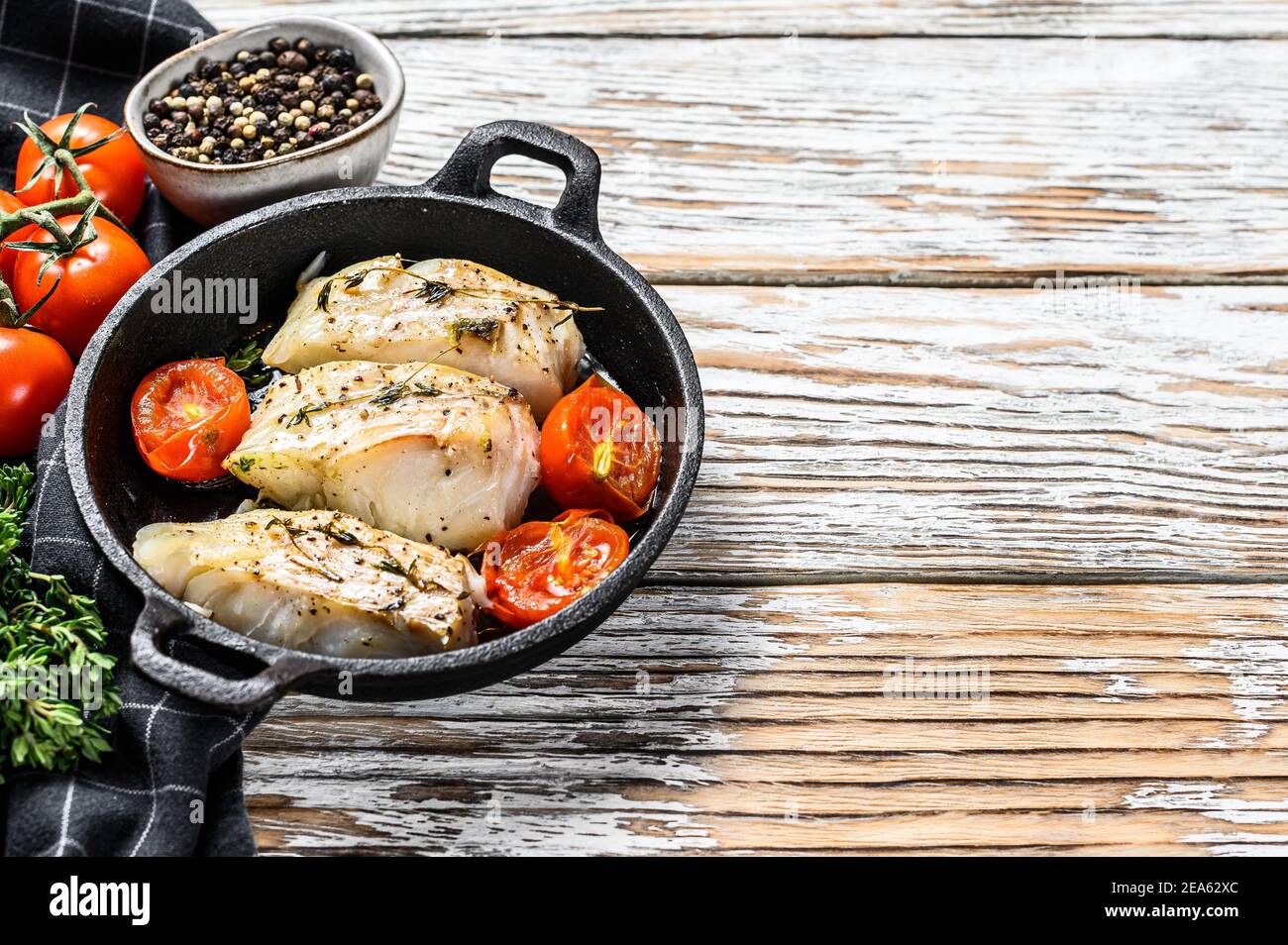 Fried cod fish fillet with spice in a cast iron pan. White background ...