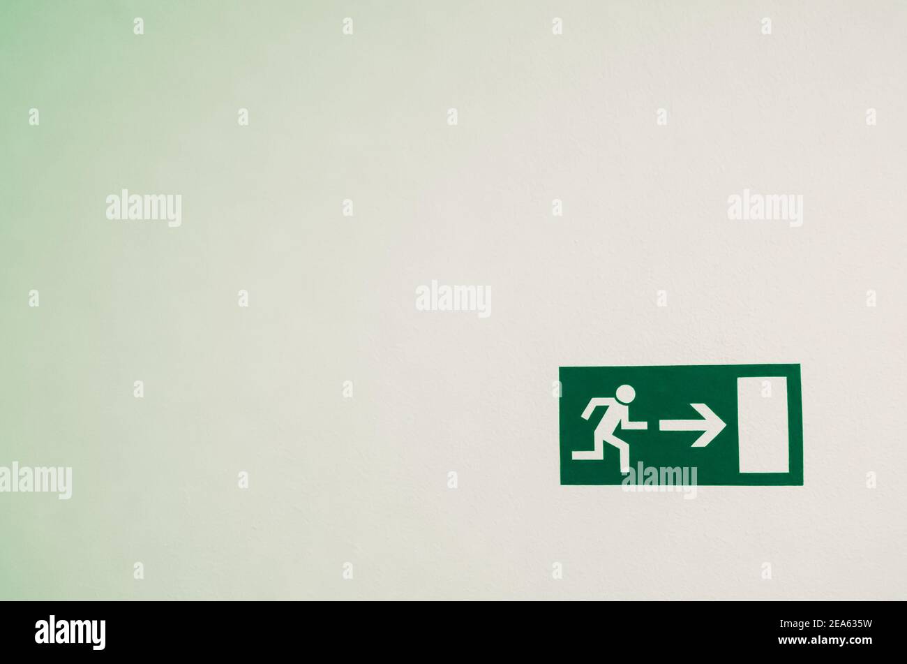 Emergency exit sign on a white wall Stock Photo - Alamy