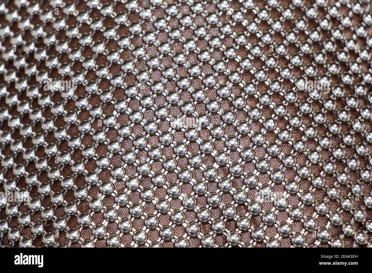 Closeup of a patterned background with shiny silver colored round ...