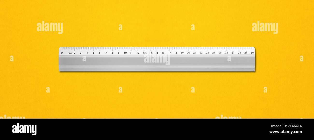 Steel metallic ruler isolated on yellow background Stock Photo - Alamy