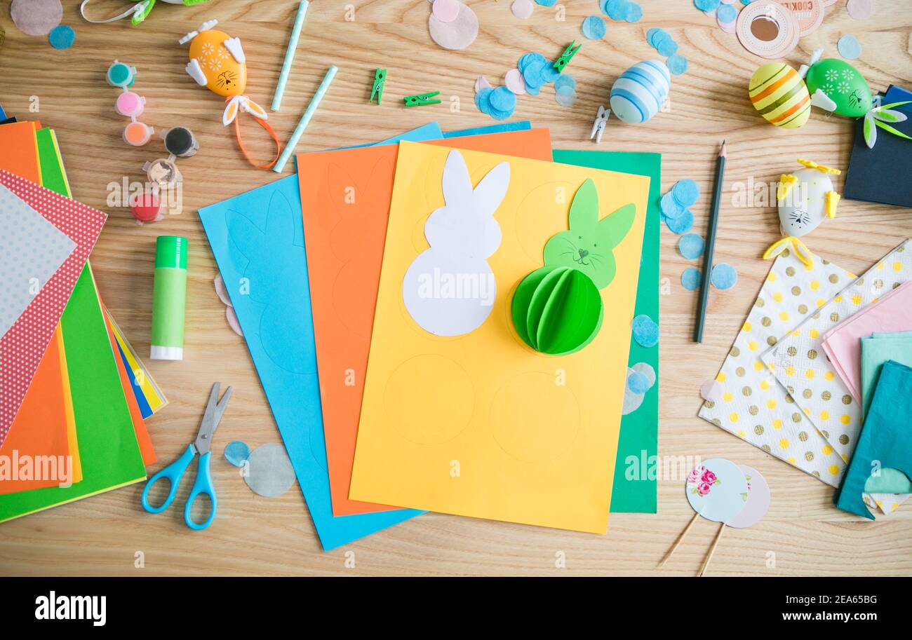 Flat lay with DIY paper Easter bunnies and colorful paper, easy crafts ...