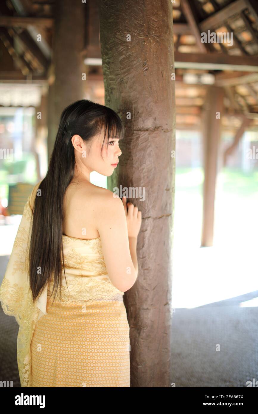 Portrait of Thai female with traditional Thai dress with temple ...