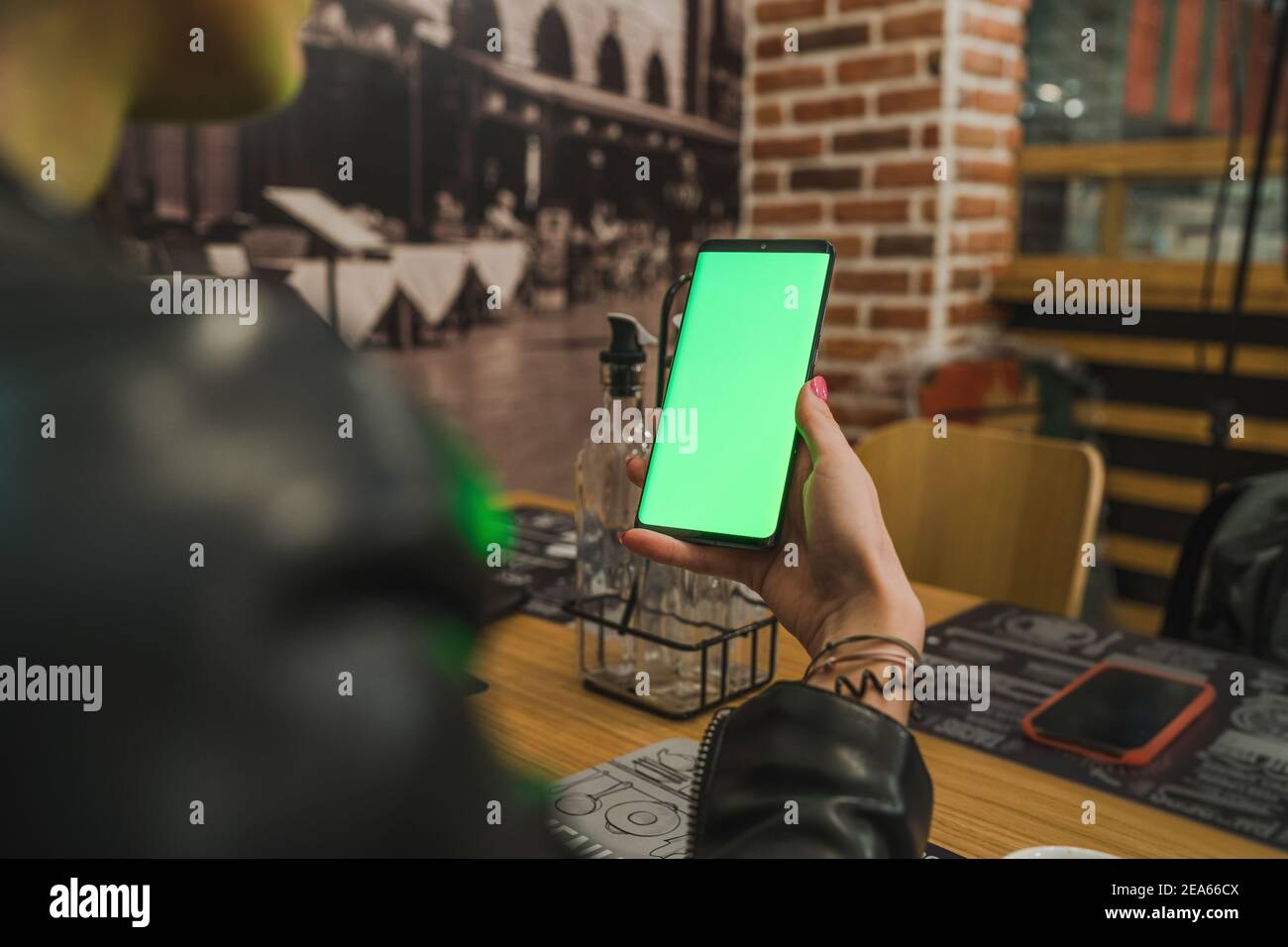 Using smartphone with green screen in coffee shop Stock Photo - Alamy