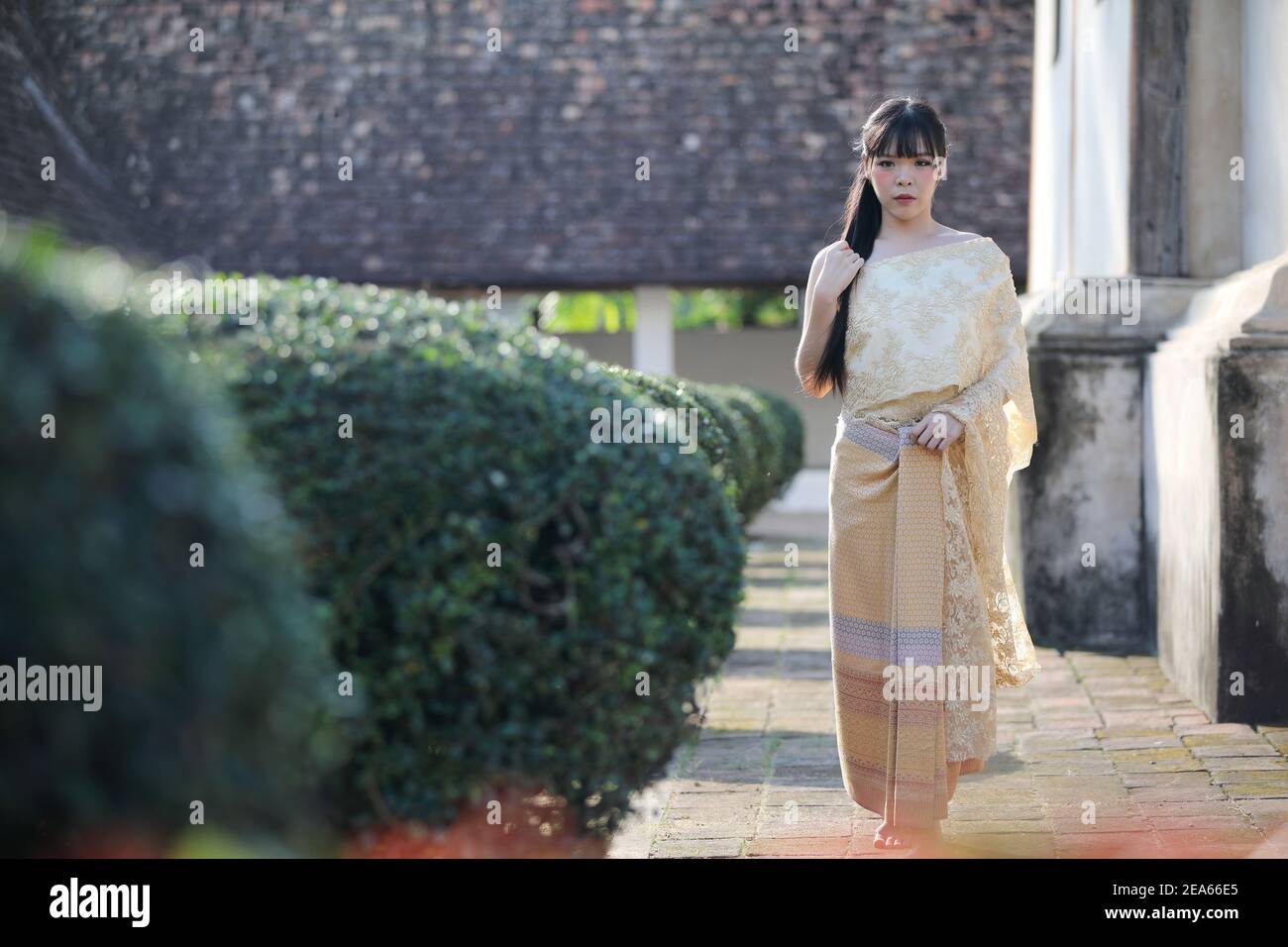 Portrait of Thai female with traditional Thai dress walking with temple ...