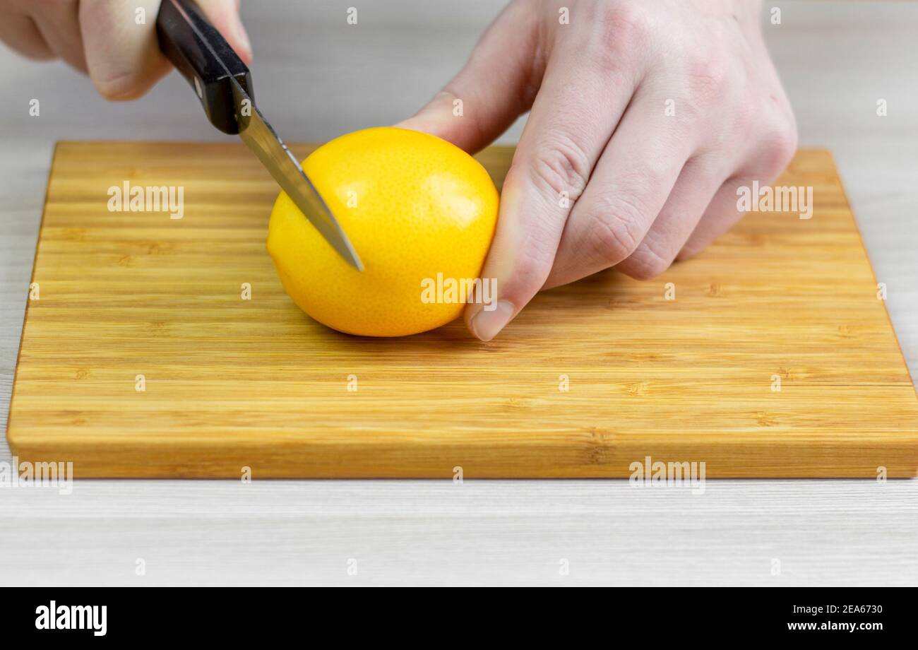 Cut the lemon.Men's hands slice a lemon Stock Photo - Alamy